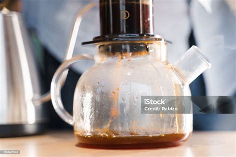 에어로 프레스 커피와 유리 냄비 클로즈업 바리스타 가 장치에 프레스와 커피 방울냄비에 Trought 에어로 프레스를 부어 대체 커피 양조 방법 바리스타 커피를 만든다 0명에