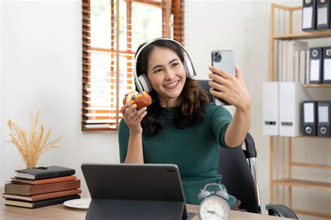 헤드폰으로 따뜻한 스웨터를 입은 젊은 학생 여성은 현대 가정 인테리어의 안락 의자에 앉아있는 Fav 노래를 듣습니다 음악 시간 편안한 멋진 재생 목록 개념 개념에 대한 스톡