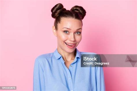 파란 점선 셔츠를 입고 파스텔 핑크 컬러 배경에 고립된 미소를 짓고 있는 입술을 핥는 여성의 사진 초상화 갈색 머리에 대한 스톡