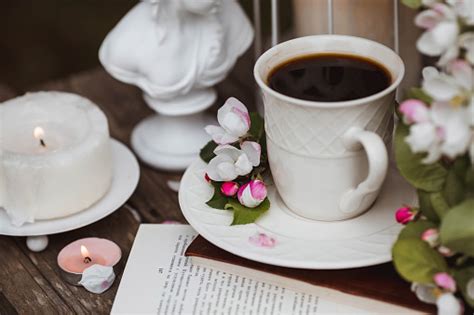 아름다운 엽서 접시 조상 양초 책 꽃이 만발한 사과 나무 꽃다발이 달린 꽃병이있는 흰색 커피 컵 아름 다운 정물입니다 봄철 좋은 아침의 개념 아침 식사에 대한 스톡 사진 및