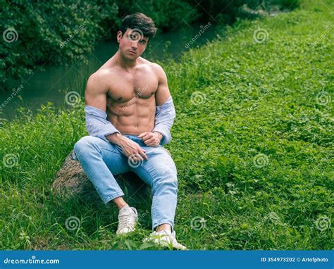 Model Poses Outdoors By A Stream In Casual Attire During Daytime Stock