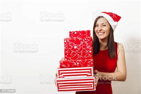 매력적인 미소와 아름 다운 백인 젊은 행복 한 여자 입고 빨간 드레스와 흰색 바탕에 선물 상자를 들고 크리스마스 모자 현재 격리와 산타 소녀입니다 새 해 휴일 2018 개념