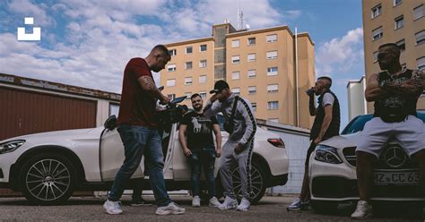 검은 티셔츠와 파란색 데님 청바지를 입은 남자가 낮에 흰색 차 옆에 서 있다 사진 Unsplash의 무료 사업 이미지