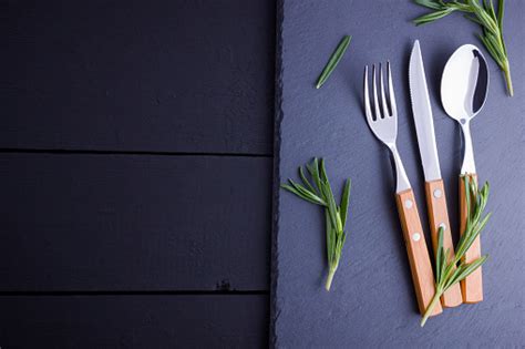 칼 칼 숟가락 슬레이트 돌에 포크 세트 로즈마리를 곁들인 크립토클러리 검은 색 배경입니다 공간을 복사합니다 맨 위 보기 0명에 대한 스톡 사진 및 기타 이미지 Istock