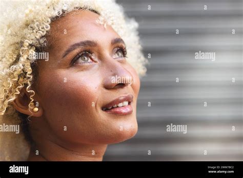 Young Biracial Woman In The City Looks Thoughtfully Upwards With Copy