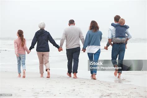 여름 방학 동안 운동을 위해 해변에서 손을 잡고 걷고 대가족 조부모 부모 및 자녀는 휴가 모험 또는 여행 중에 바다를 따라 자연 속에서 야외 산책을합니다 가족에 대한 스톡