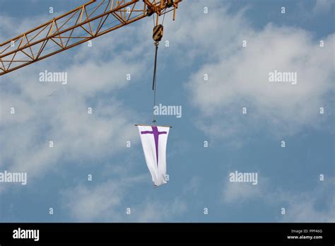 A Flag Hanging From A Crane Suspended Above The Construction Site For The Extension Of The
