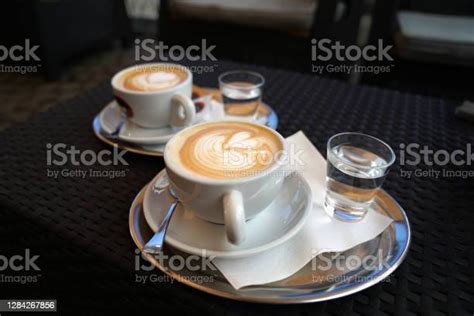 고급 현대 카페에서 예술라떼 아트와 수돗물 한 잔을 곁들인 카푸치노 커피 2컵 갈색에 대한 스톡 사진 및 기타 이미지 갈색 구이 기포 음료 Istock