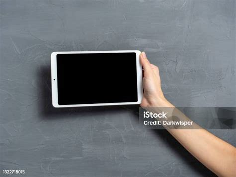 한 여성의 손이 회색 질감의 배경에 흰색 태블릿을 들고 있습니다 전자 태블릿의 화면에 삽입 할 장소 공란에 대한 스톡 사진 및 기타 이미지 Istock