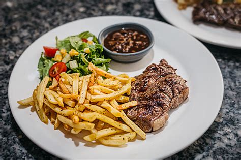 중간 희귀 스테이크는 프렌치 프라이드와 샐러드 스톡 사진과 함께 화이트 플레이트에 제공됩니다 0명에 대한 스톡 사진 및 기타 이미지 Istock
