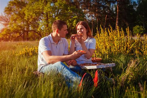 피자를 먹고 밖에 서 채팅 사랑에 젊은 부부 여자와 남자 일몰 시 낭만적인 피크닉 데입니다 라이프 스타일 건강에 좋지 않은 음식에 대한 스톡 사진 및 기타 이미지 Istock