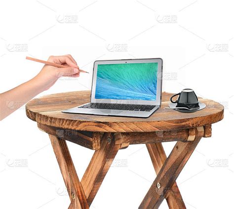 手里拿着铅笔和笔记本电脑放在木桌上