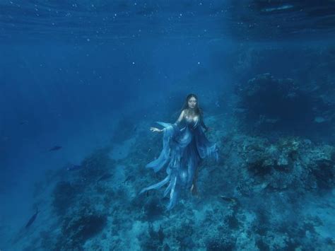 یک پری دریایی پری جادویی در لباس آبی پرواز در کف اقیانوس ملکه دریا و