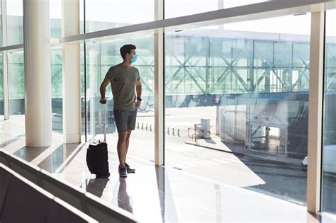 얼굴 마스크를 쓰고 공항에서 비행기를 기다리는 남자 전염병과 개인 보호 기간 동안 여행 테마 Brand Name Smart