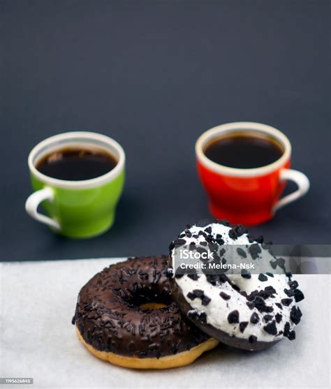 초콜릿 도넛과 커피 냅킨에 두 개의 아름다운 맛있는 도넛과 어두운 배경에 녹색과 빨간색의 향기로운 뜨거운 커피 두 개의 작은 컵 0명에 대한 스톡 사진 및 기타 이미지