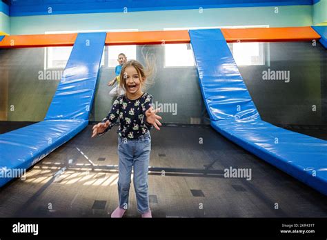 Brother With Sister Playing At Indoor Play Center Playground Jumping In Trampoline Stock Photo