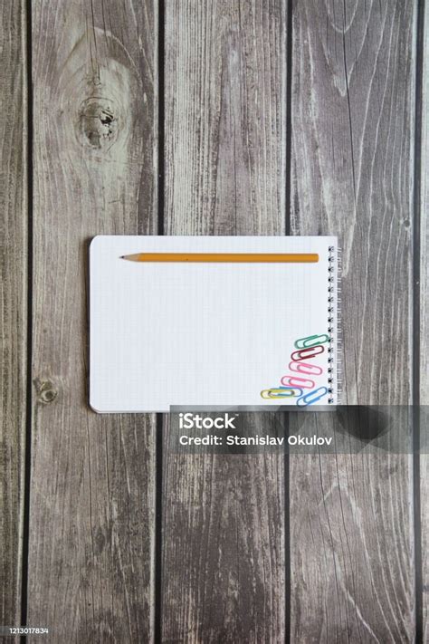 간단한 흑연 연필과 종이 클립 체크 용지에 빈 흰색 시트와 메모장 나무 보드의 배경에 놓여 0명에 대한 스톡 사진 및 기타