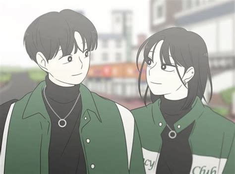 Two People Standing Next To Each Other With Buildings In The Background