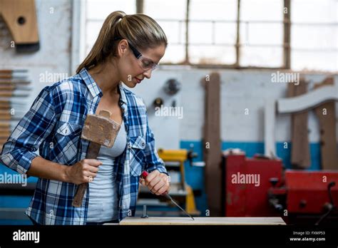 Female Carpenter Using Mallet And Chisel Stock Photo Alamy