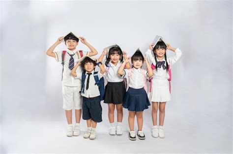 색 배경 에 포즈 를 취 하는 귀여운 아시아 어린이 들 의 그룹 프리미엄 사진