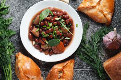 어두운 배경의 슬레이트 테이블에 신선한 호밀 빵과 마늘을 곁들인 흰 접시에 허브를 곁들인 콩 수프 배경 주제에 대한 스톡 사진 및 기타 이미지 Istock