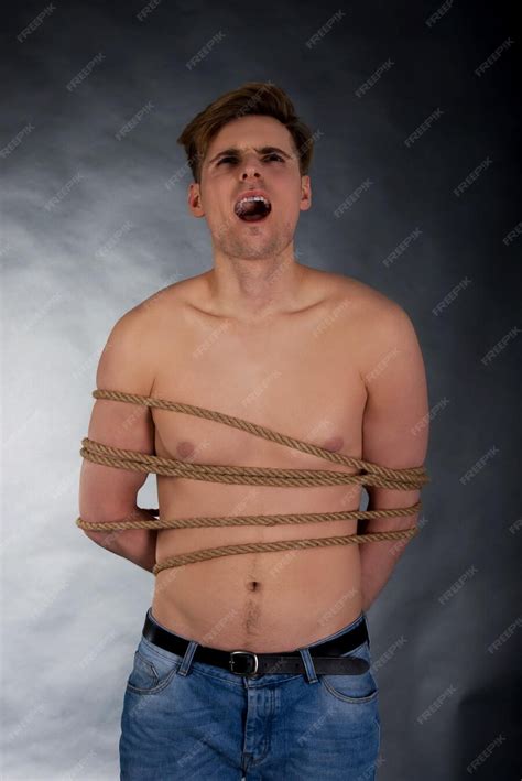 Premium Photo Shirtless Young Man Tied With Rope Shouting Against