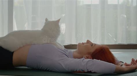 Redhead Woman Relaxes With Her Cat On Gym Mat After Morning Workout Routine Stock Footage