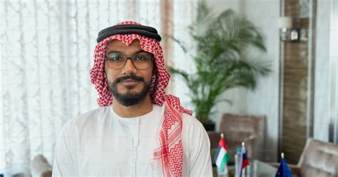 빨간 두건과 흰 코트를 입은 남자가 카메라 앞에 서 있다 사진 Unsplash의 사업 이미지