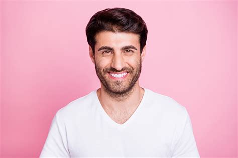 긍정적 인 쾌활한 당당한 중동 남자 모습의 초상화는 분홍색 색상 배경 위에 고립 된 흰색 의상을 입고 봄의 주말을 듣습니다 T 셔츠에 대한 스톡 사진 및 기타 이미지