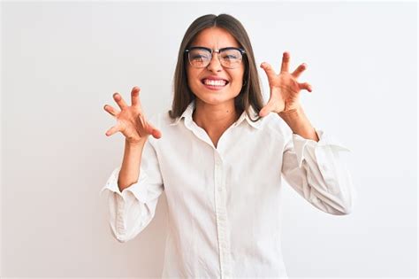 고양이 공격적이고 섹시한 표정으로 발톱 제스처를하고 재미 웃고 고립 된 흰색 배경 위에 서 안경을 착용 젊은 아름다운 사업가