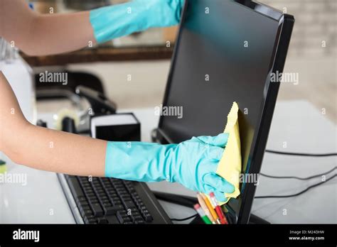 Close Up Of A Woman S Hand Cleaning The Desktop Screen With Yellow Rag In Office Stock Photo Alamy