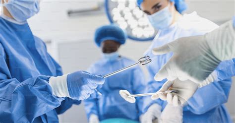 수술실에서 낮은 각도로 촬영하면 조수가 수술 중 외과의에게기구를 나눠줍니다 외과 의사가 수술을 수행합니다 수술을 수행하는 전문 의사 사진 Unsplash의 외과 이미지