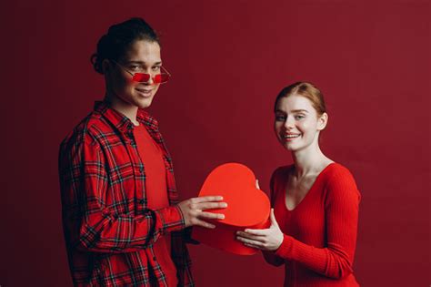 젊은 남자는 빨간 배경 스튜디오에서 발렌타인 데이에 그의 여자 친구에게 하트 모양의 상자를 제공합니다 18 19세에 대한 스톡 사진 및 기타 이미지 Istock