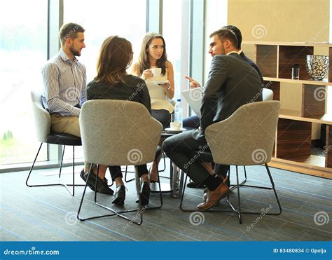 Group Of Five Young People Discussing Something While Sitting At The