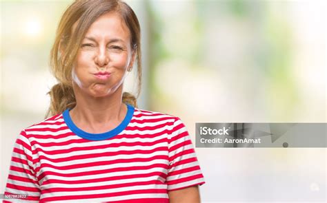 재미 있은 얼굴 뺨 피 격리 된 배경 위에 중 년 수석 히스패닉 여자 입 어 미친 식으로 팽창 가득 찬에 대한 스톡 사진 및