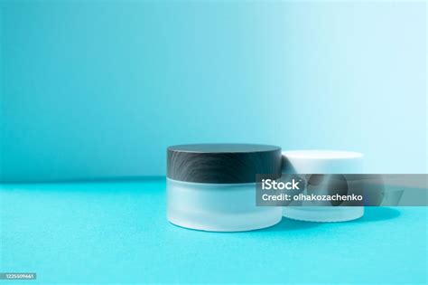 파란 종이 배경에 얼굴과 눈 보습 제 크림 서리가 내린 유리 병 카피 스페이스스킨케어 내추럴 뷰티 제품 젖빛 유리에 대한 스톡 사진 및 기타 이미지 Istock