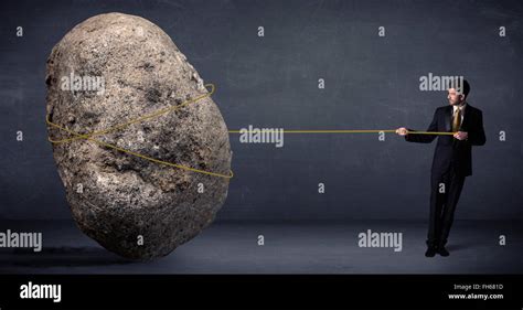 Businessman Pulling Huge Rock With A Rope Stock Photo Alamy