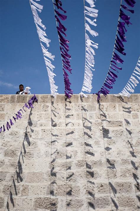 Man Assembling The Decoration For Catholic Celebrations At The Top Of White Sillar Building