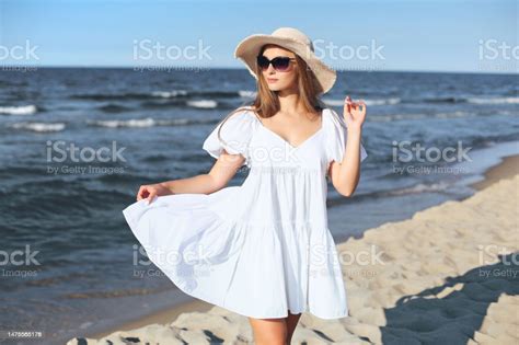 행복한 웃는 금발 여자가 선글라스와 모자를 쓰고 바다 해변에서 포즈를 취하고 있다 18 19세에 대한 스톡 사진 및 기타 이미지 18 19세 건강한 생활방식 관광