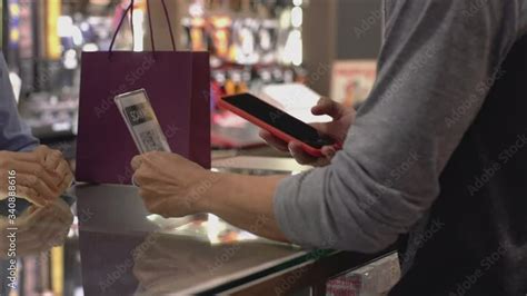 An Upwardly Mobile Asian Muslim Man Using A Mobile Phone To Scan The QR Code To Pay For A