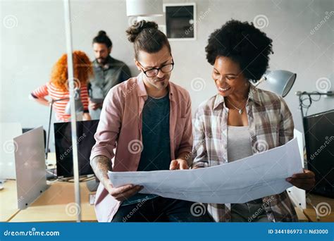 Engineers Helping Design Work On Blueprints Collaborate On Structural Analyzing Of Project
