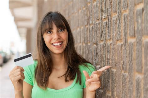Jovem Mulher Segurando Um Cartão De Crédito Ao Ar Livre Surpreso E