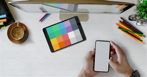 데스크톱 컴퓨터 사무용품 커피 머그잔이 있는 사무실 흰색 책상 테이블에서 휴대폰을 사용하는 남자 평면도 작업 공간 및 빈