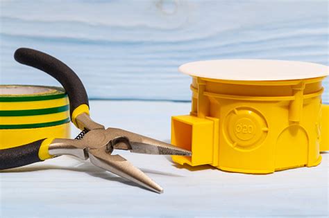 Kotak Sambungan Listrik Berwarna Kuning Dan Alat Yang Biasanya Digunakan Dalam Proses Pemasangan