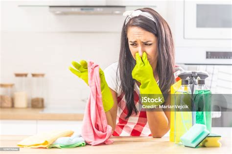 냄새 나는 헝겊을 들고 있는 여성에게는 손가락으로 코를 잡고 부엌 책상에 기대어 그녀를 둘러싼 청소 물건 불쾌한 냄새에 대한 스톡 사진 및 기타 이미지 Istock