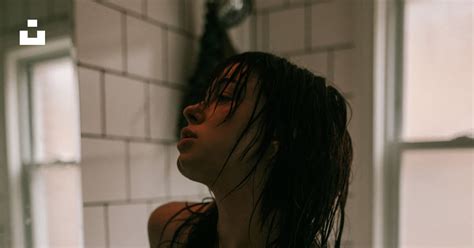 A Woman Standing In Front Of A Bathroom Sink Photo Free Person Image