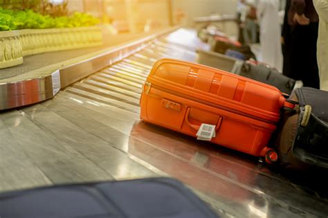 비행기로 여행 한 후 스캐너를 확인하는 지점에서 수하물을 기다리는 여행자 공항 카운터 배경의 컨베이어 벨트에 수하물 X선 기계 밴드 비즈니스 여행 개념 공항에 대한 스톡