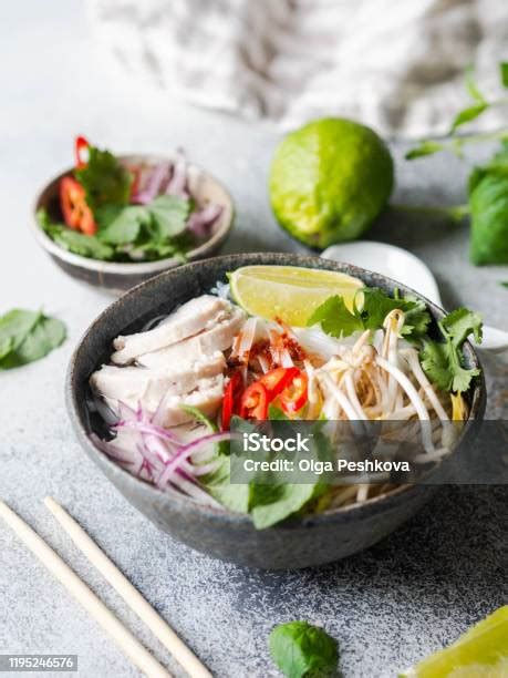 전통적인 베트남 수프 닭고기와 쌀 국수 민트와 실란트로 붉은 양파 칠리 콩나물 회색 배경에 라임 그릇에 포 가 아시아 음식