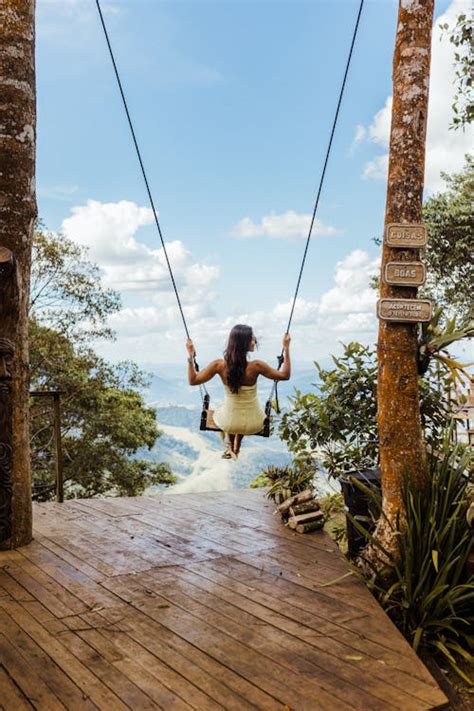 아름다운 산 전망을 바라보는 스윙 위의 여성 · 무료 스톡 사진