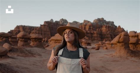 작업복을 입은 여성이 사막 풍경에서 포즈를 취하고 있습니다 사진 Unsplash의 무료 여자 이미지